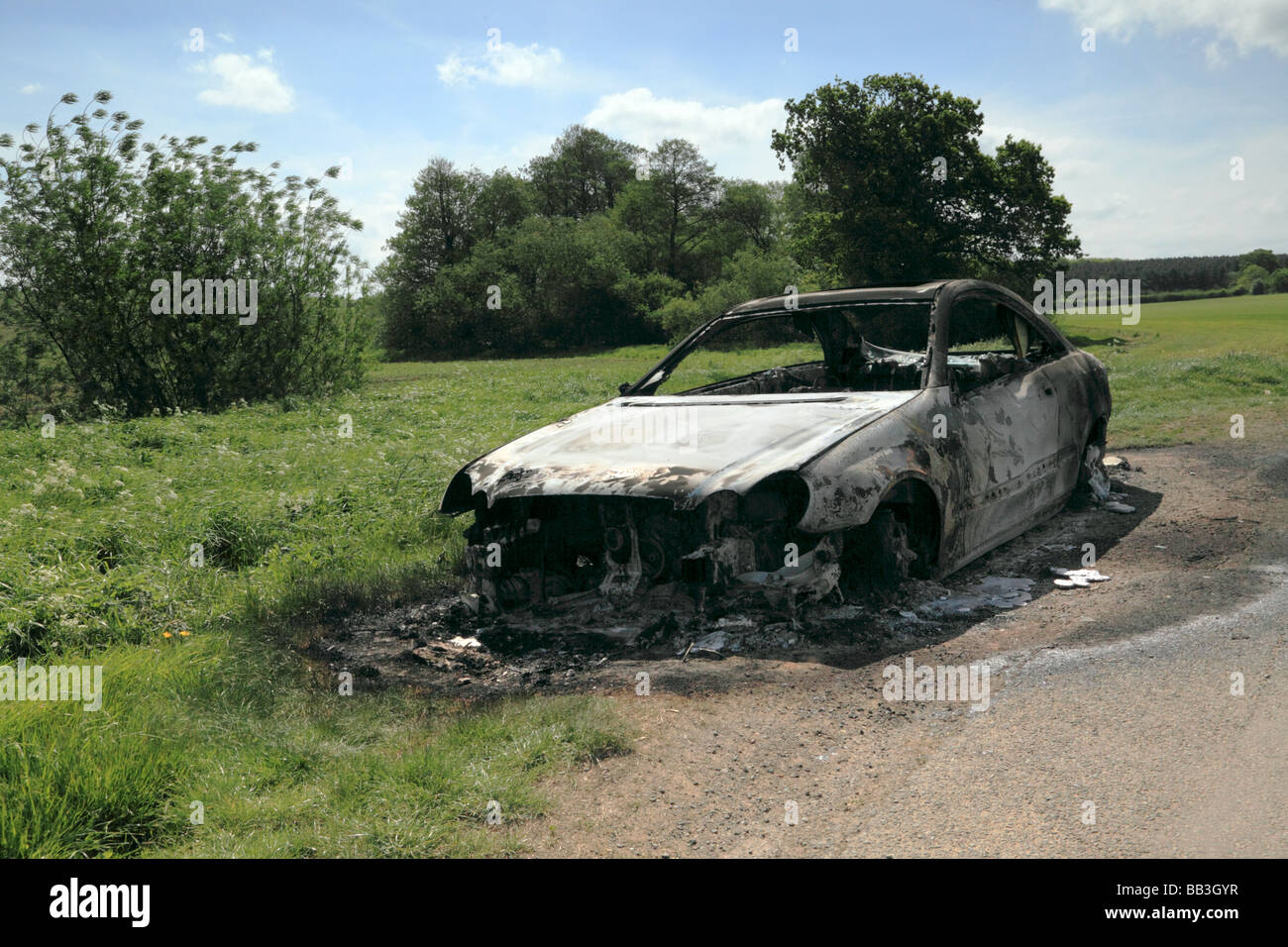 A burnt out shell of a Mercedes Benz Coupe left in rural farmland Stock ...