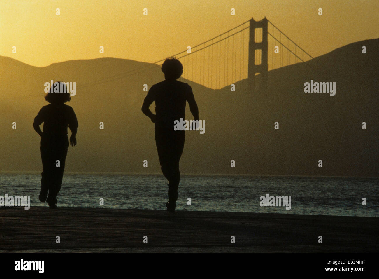 California, San Francisco, joggers running along San Francisco Bay with ...