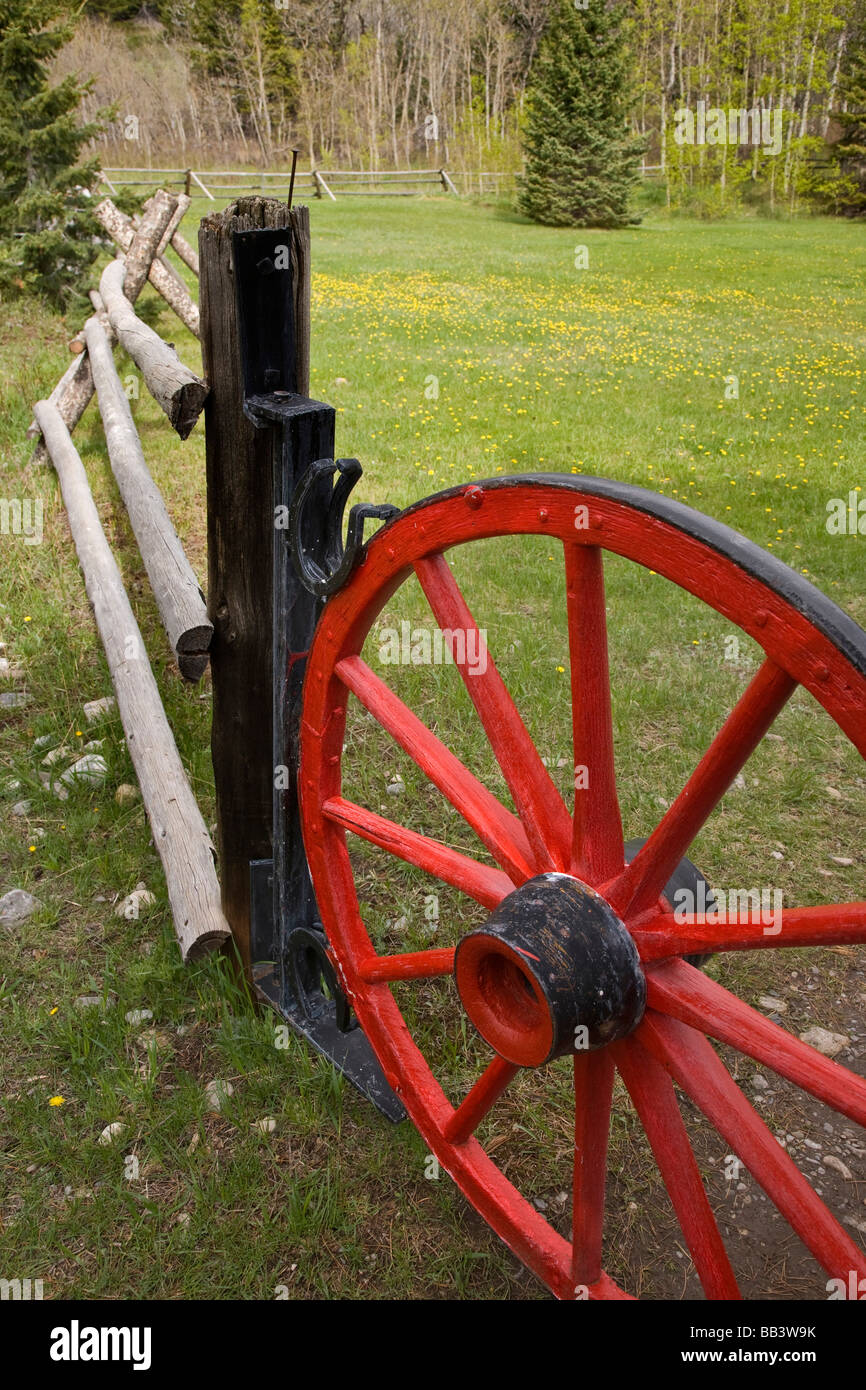 USA, Montana, Pine Butte Guest Ranch. Fence and red wagon wheel gate ...