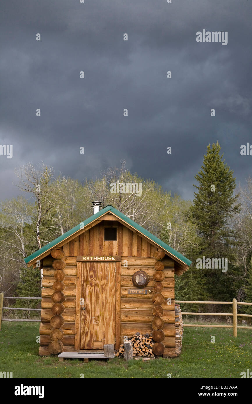 USA, Montana, Little Belt Mountains. Storm clouds over log bath house ...