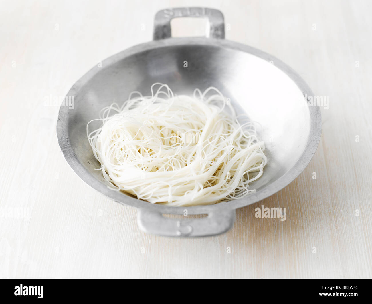 Uncooked rice noodles in wok Stock Photo - Alamy