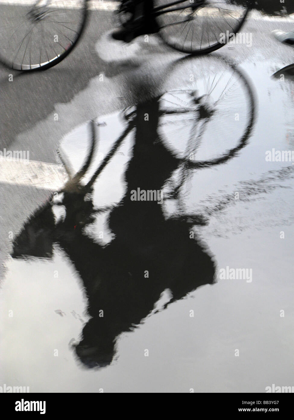 Reflection of bicyclist in puddle Stock Photo - Alamy