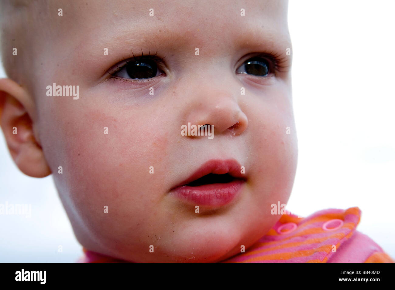 Toddler Face orange top enigmatic Stock Photo - Alamy