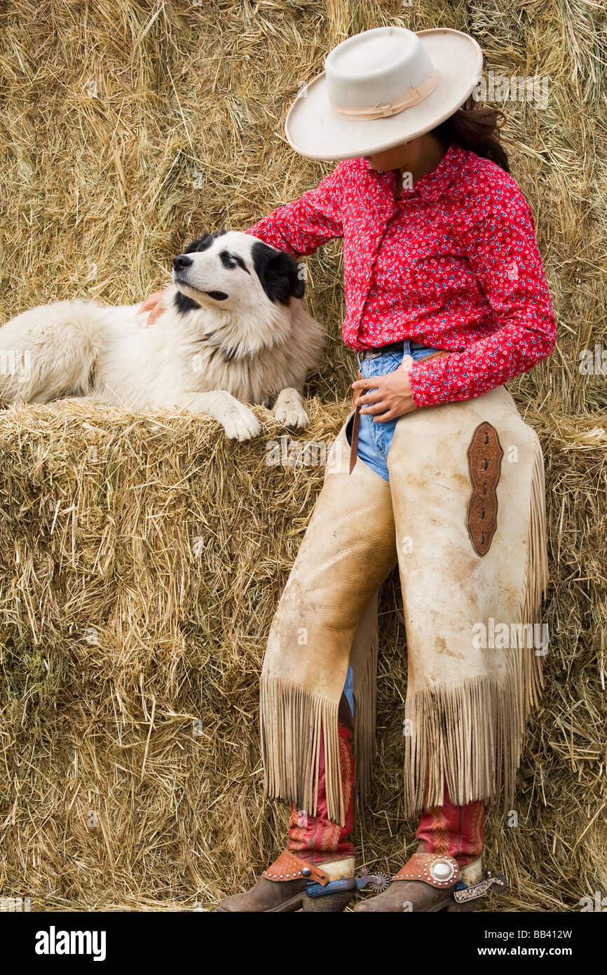 USA, Oregon, Seneca, Ponderosa Ranch. Cowgirl giving her dog an ...