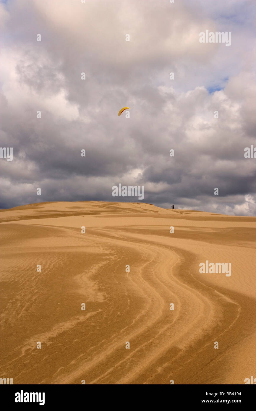 USA, Oregon, Siuslaw National Forest, Umpqua Dunes. Man flying a kite ...