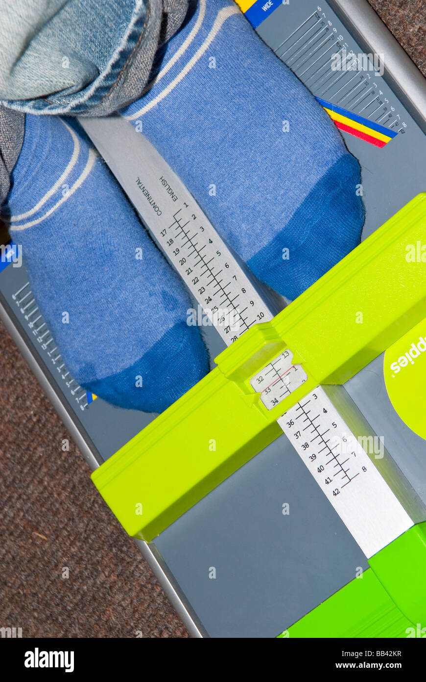 A small young child having their feet measured for fitting new shoes in ...
