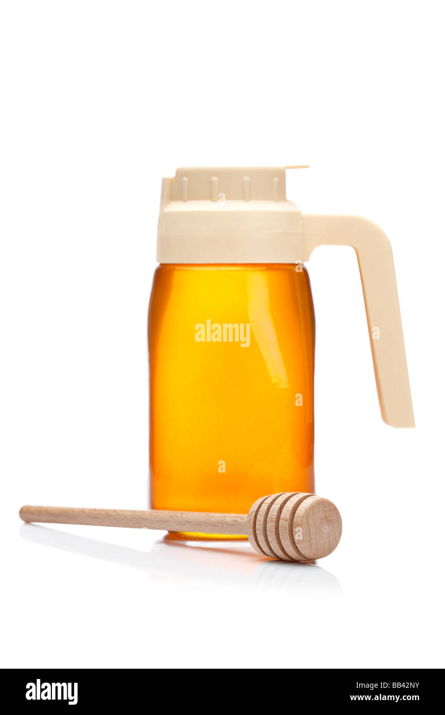 Honey pitcher and wooden drizzler reflected on white background Focus ...
