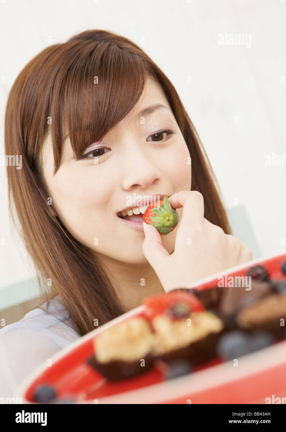 Woman eating strawberry Stock Photo - Alamy