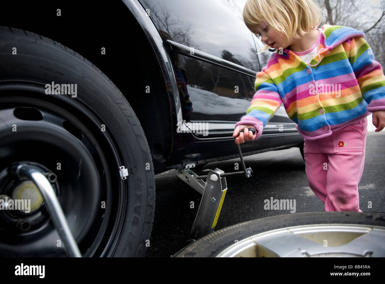 2-3 year old girl changing a flat tire, Cumberland, Maine Stock Photo ...