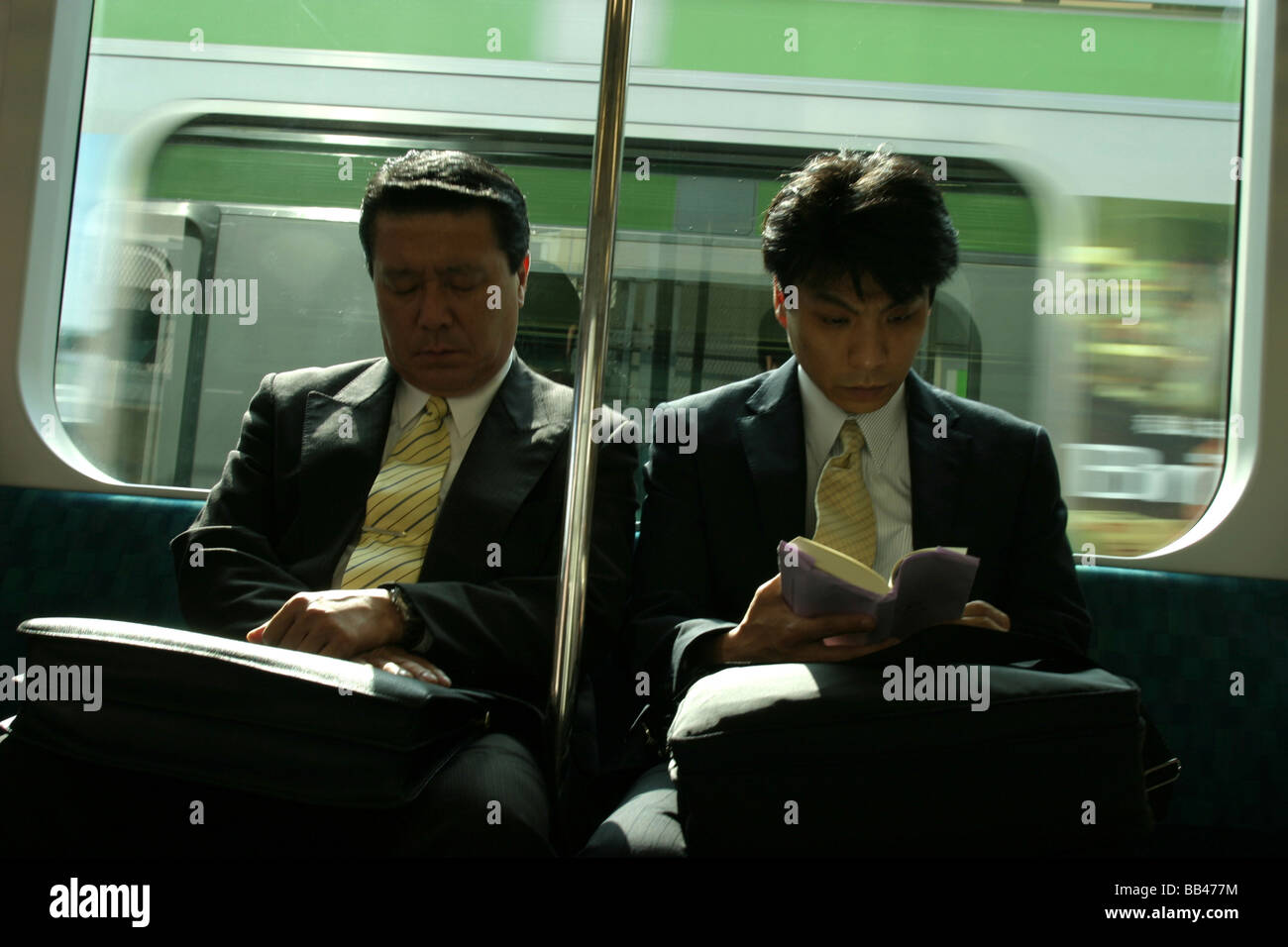 Two men sit on a train in Tokyo, Japan Stock Photo - Alamy