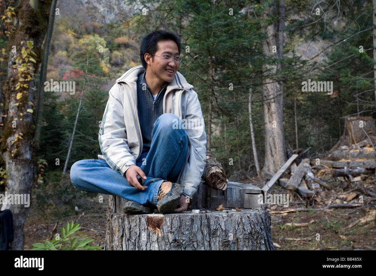 A man sitting on a stump in Yunnan Province, China Stock Photo - Alamy