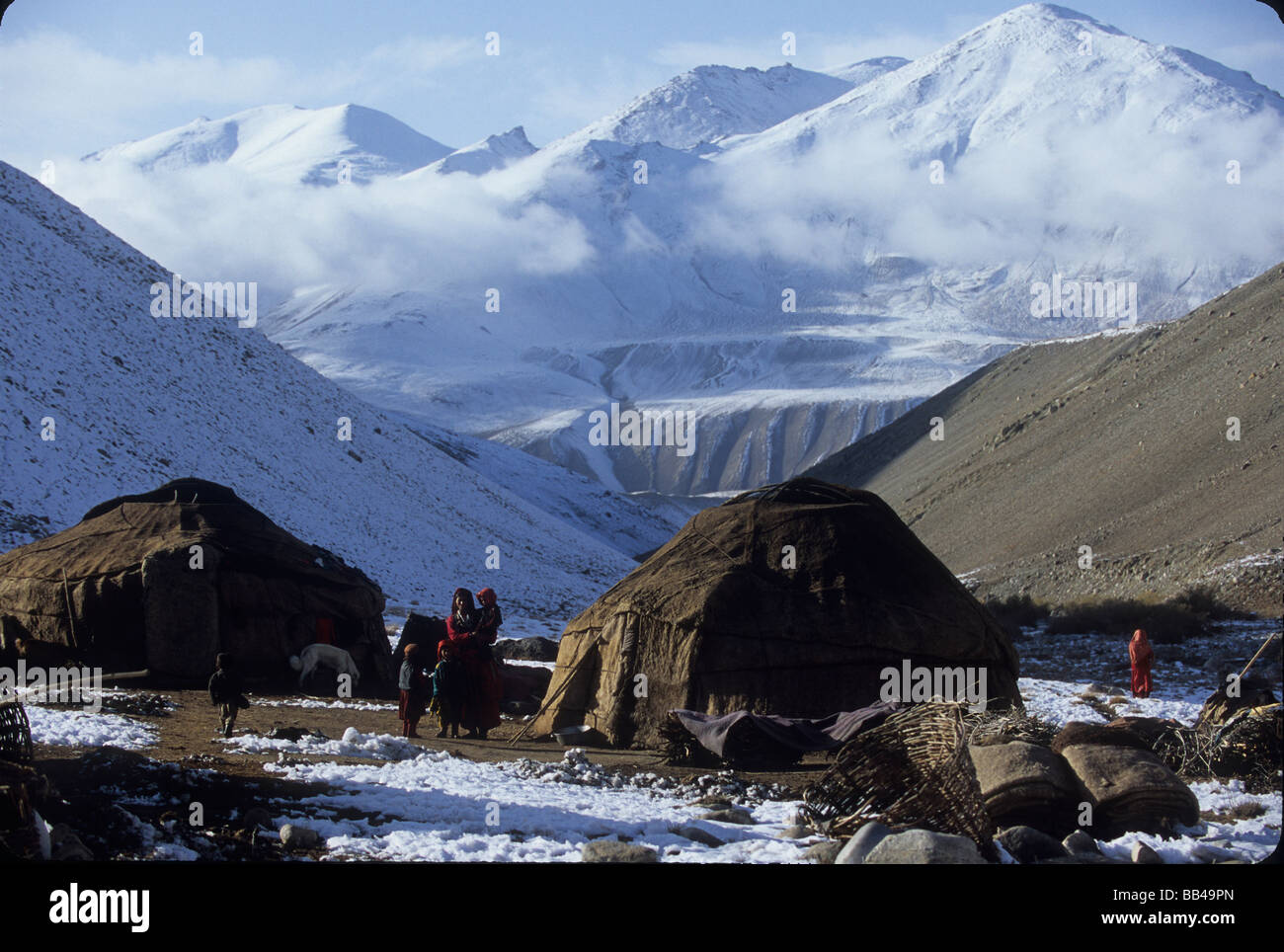 A family pause outside of their yurt at a shepherds' camp surrounded by ...