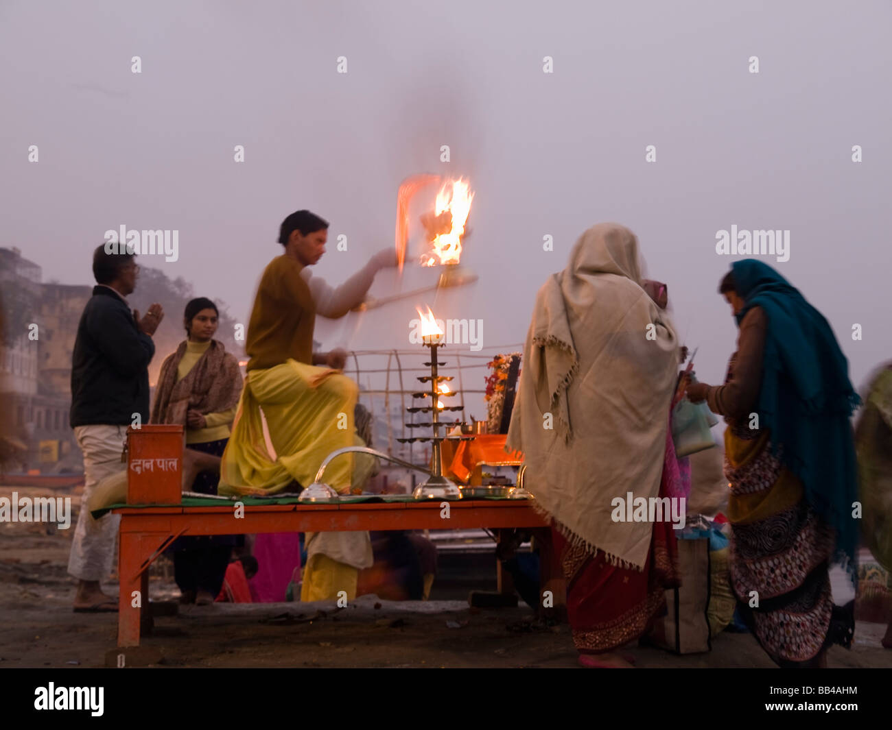 A Hindu priest performs a ritual at dawn on the bank of the holy river ...