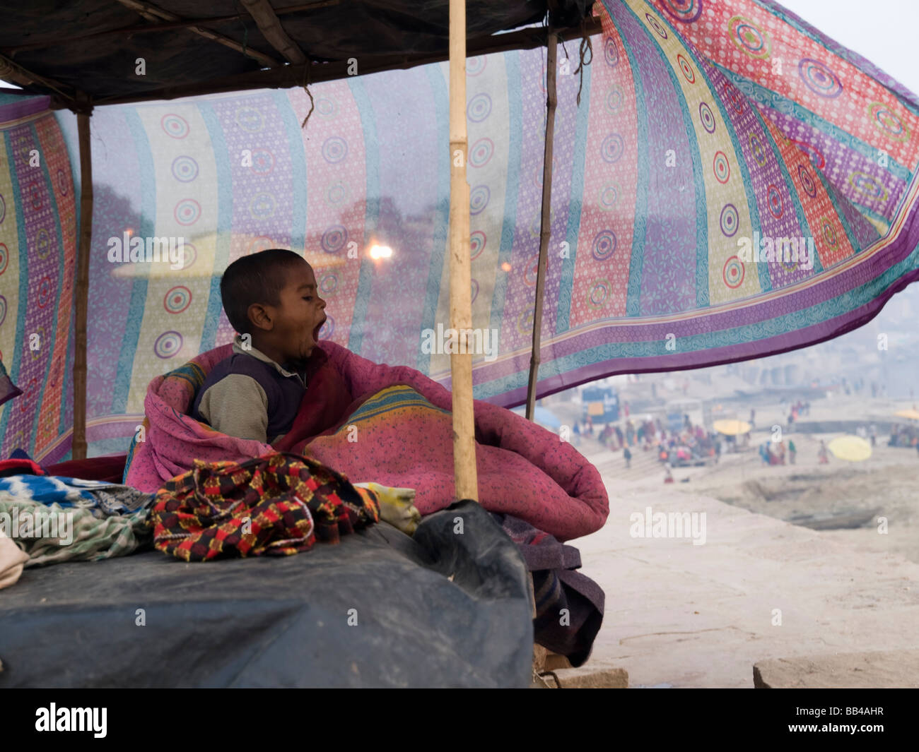 Boy wakes up along the holy river Ganges Stock Photo - Alamy