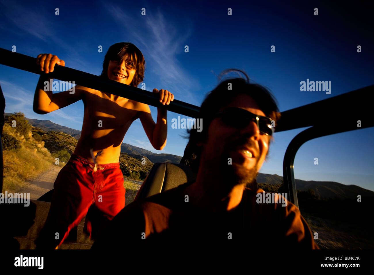 Man and young boy drive their jeep back to their RV (recreational ...
