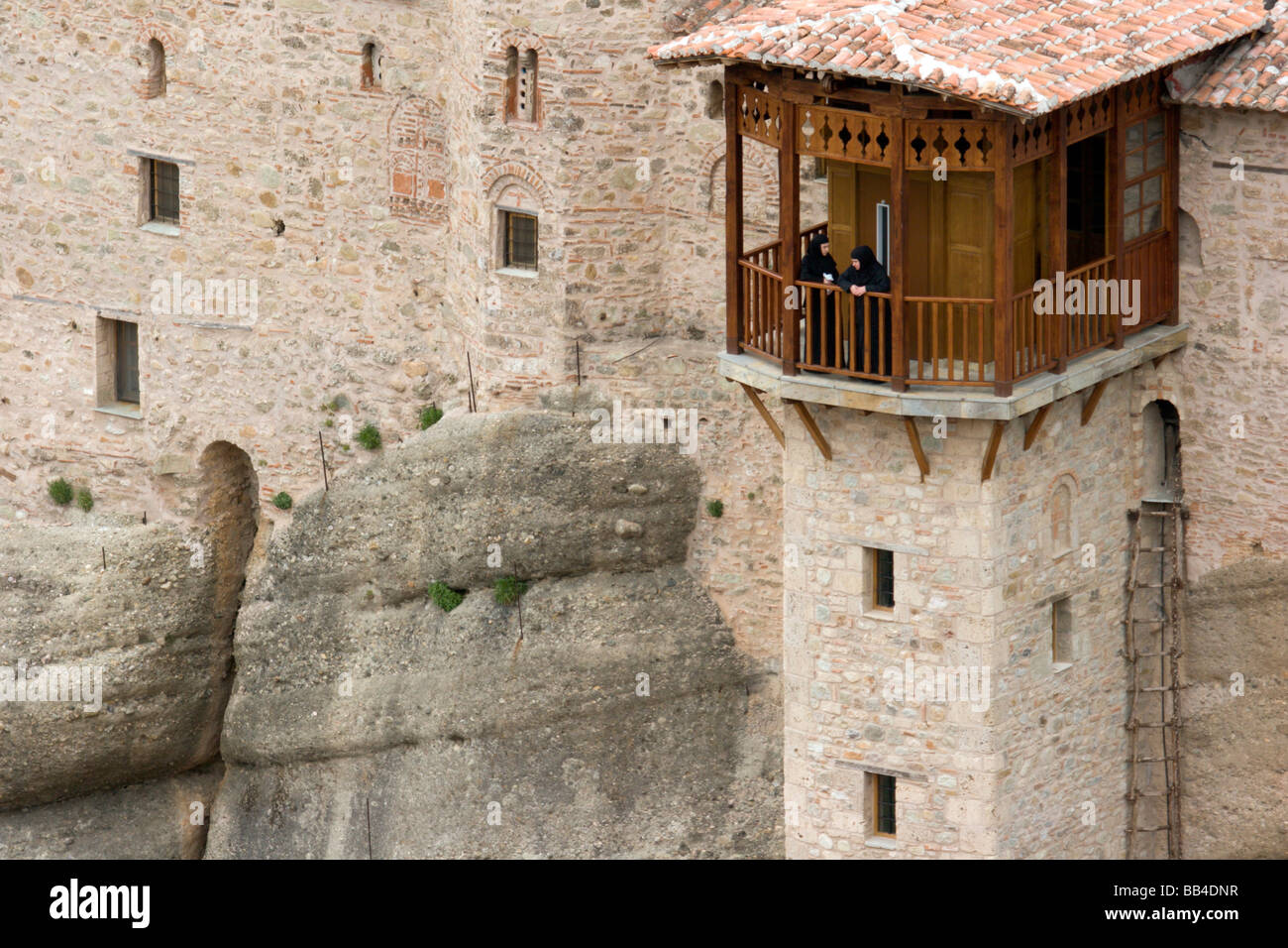 Europe, Greece, Meteora. Two nuns stand on balcony at Saint Barbara ...