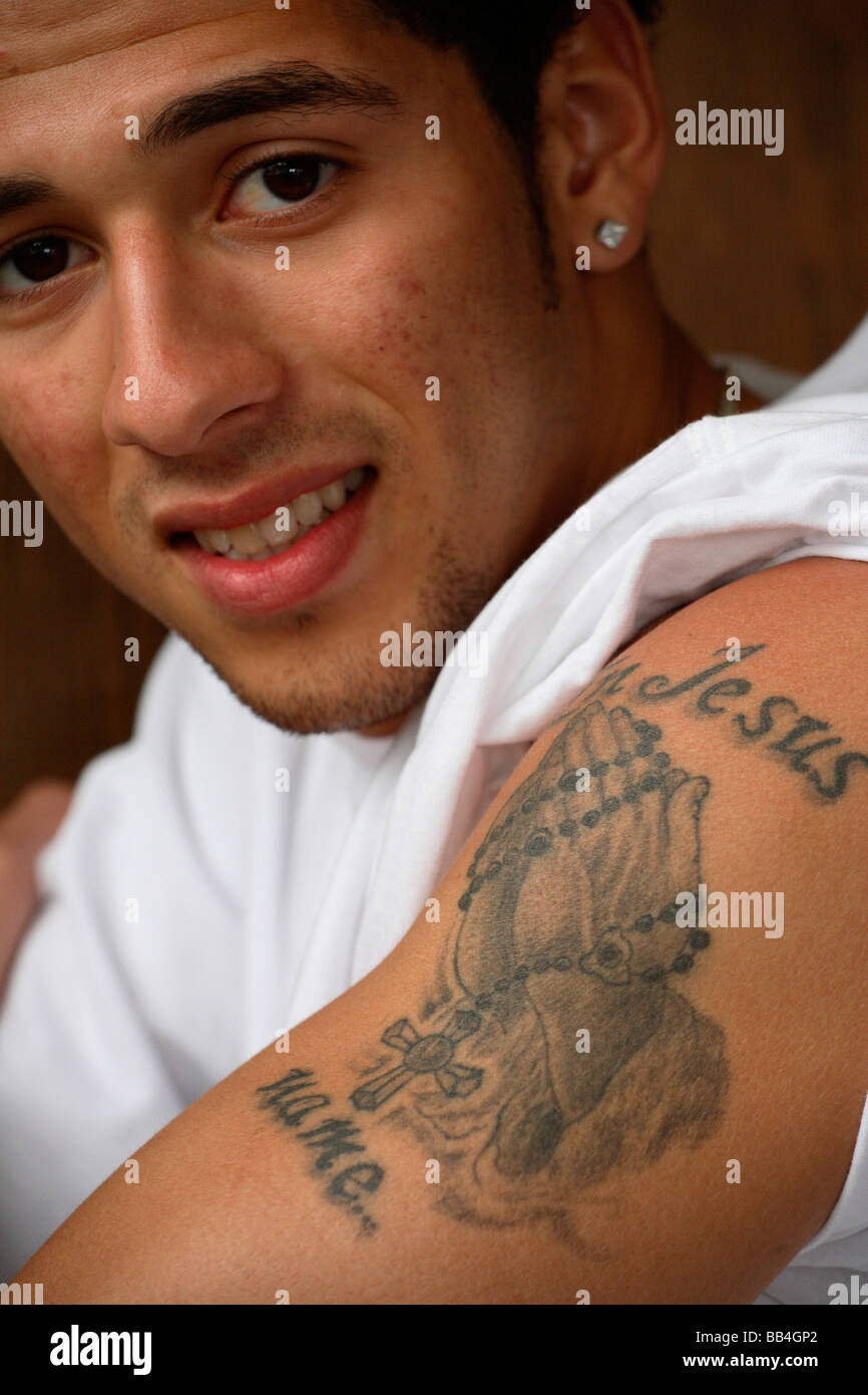 A religious tatoo on a young hispanic students arm that reads Stock ...