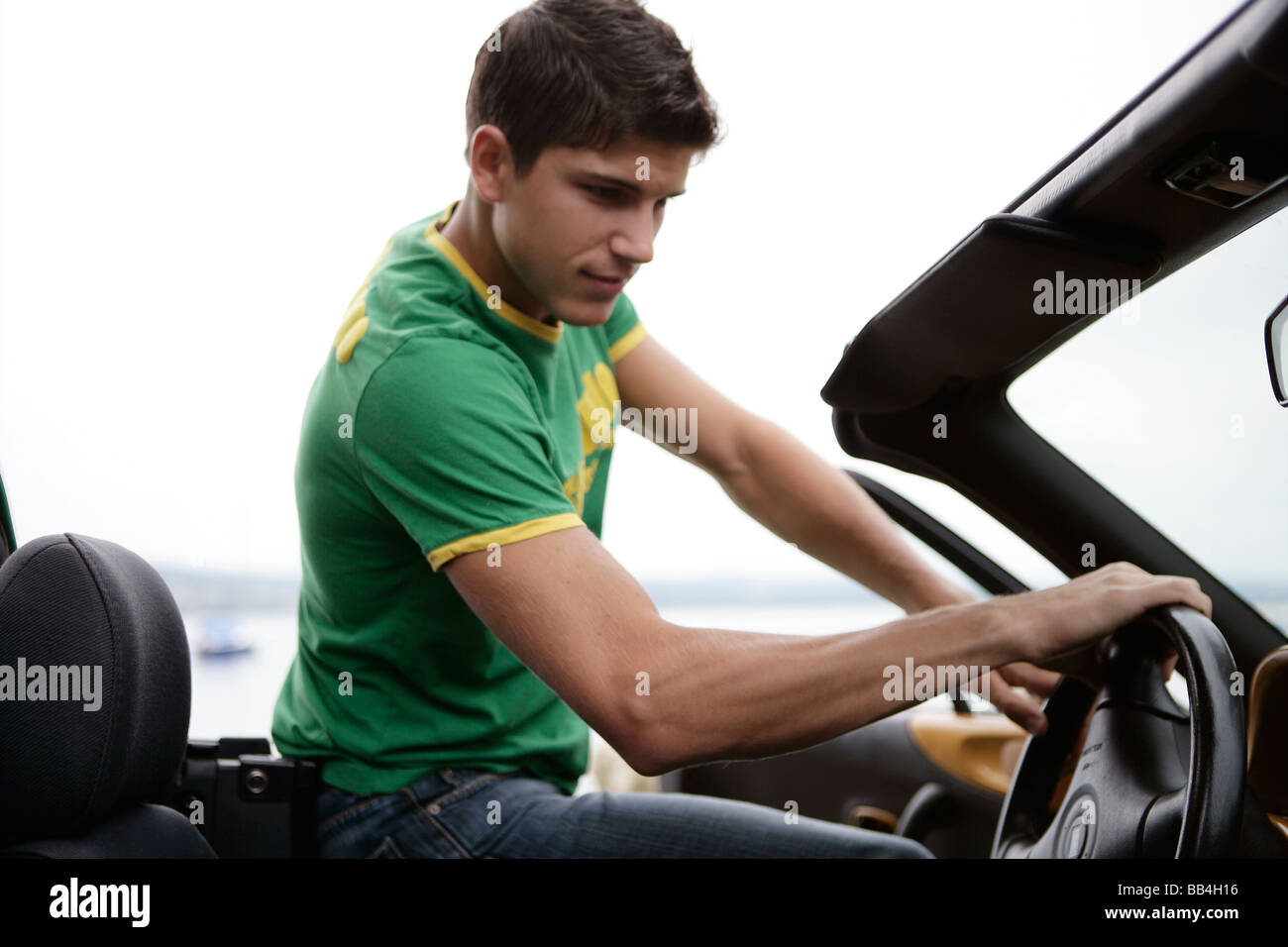 Young man is getting in a car Stock Photo - Alamy