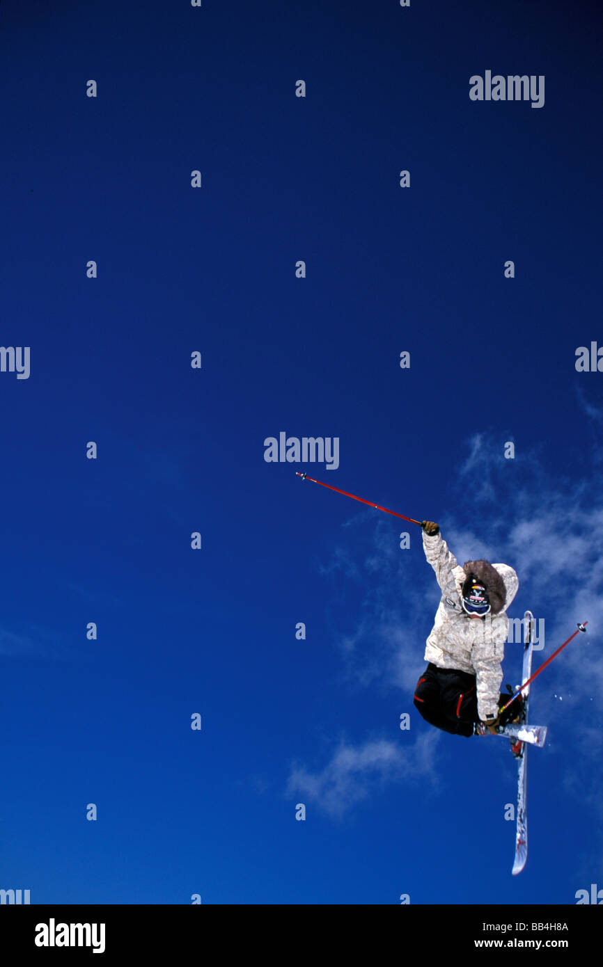 Freestyle skier grabbing his skis while flying through the air Stock ...