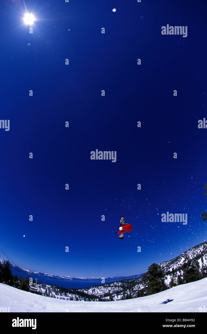 Snowboarder flying high above a blue lake Stock Photo - Alamy