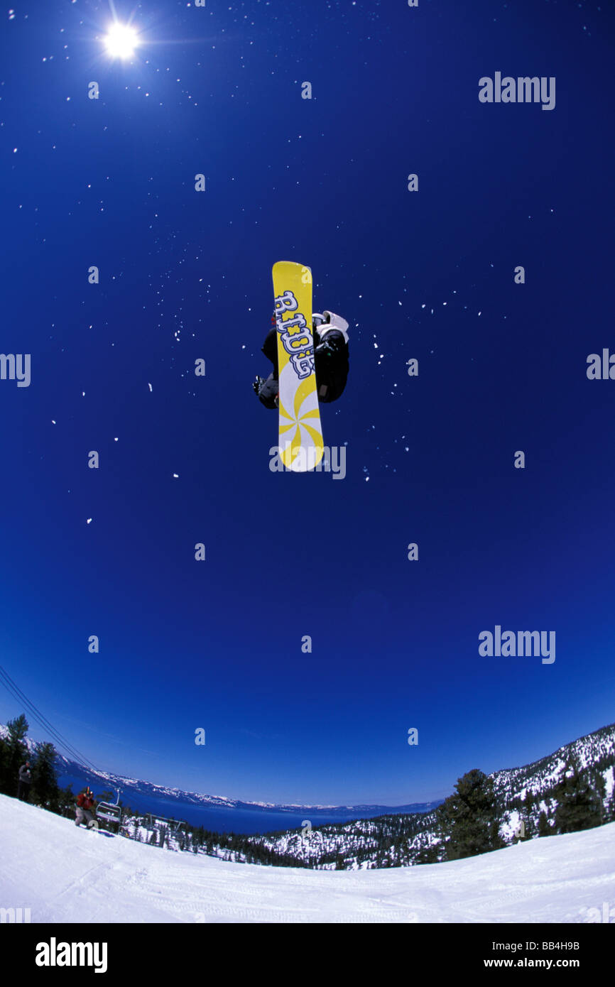 Snowboarder flying high above a blue lake Stock Photo - Alamy