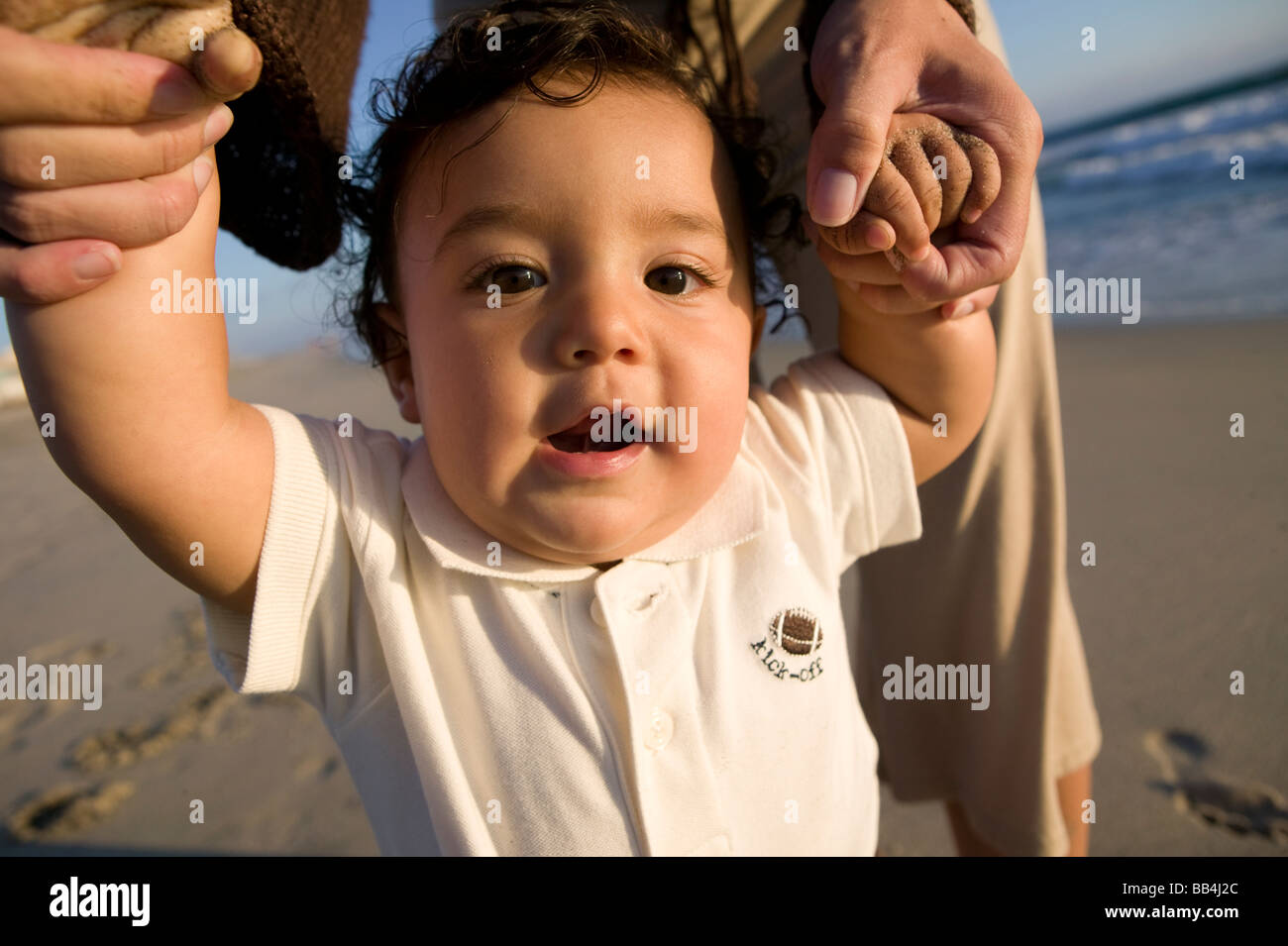 mom helps baby take first steps on the beach Stock Photo - Alamy