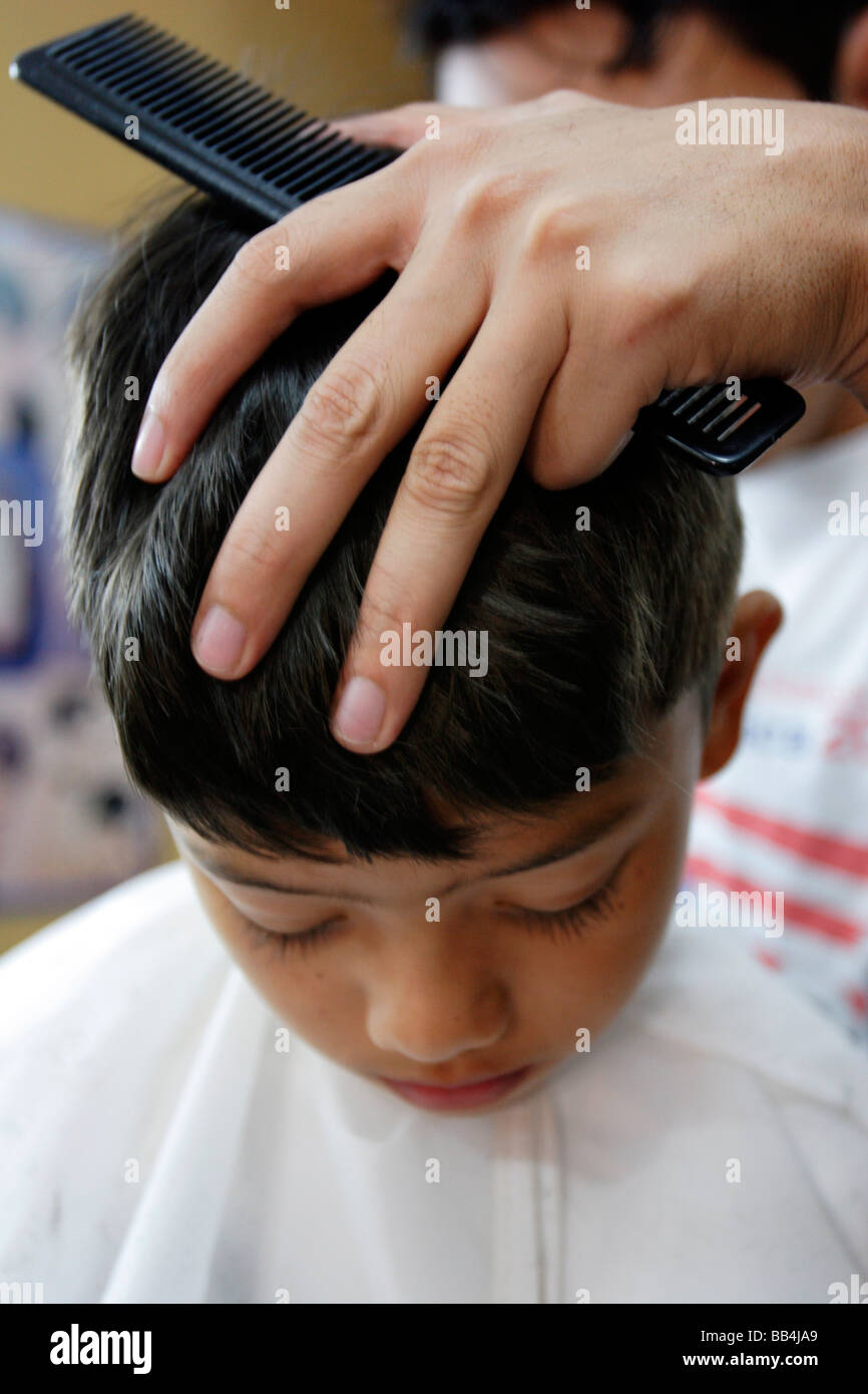 A young hispanic little boy gets his hair cut in Antigua, Guatemala ...