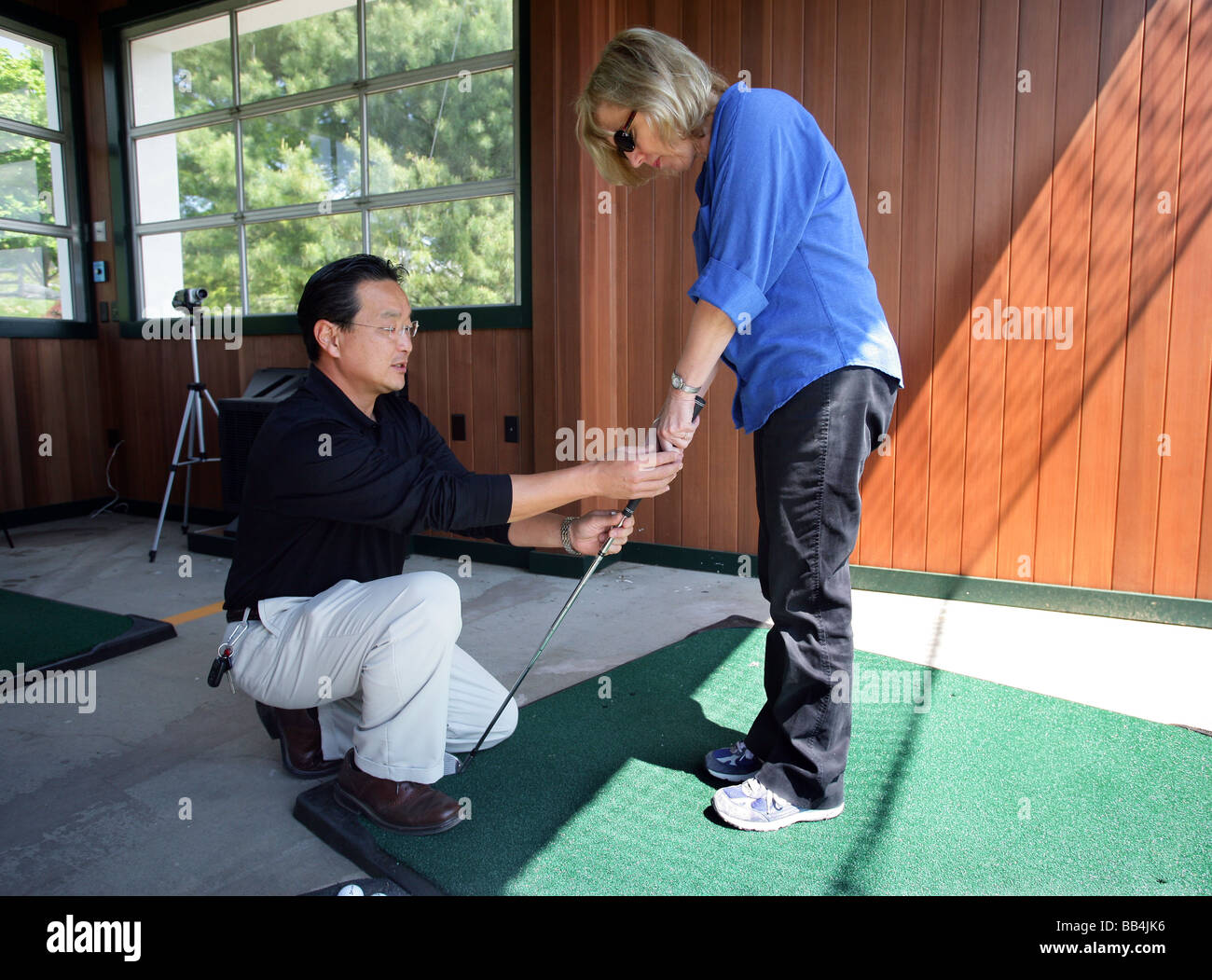 A woman gets a golf lesson from a Golf Pro Stock Photo - Alamy