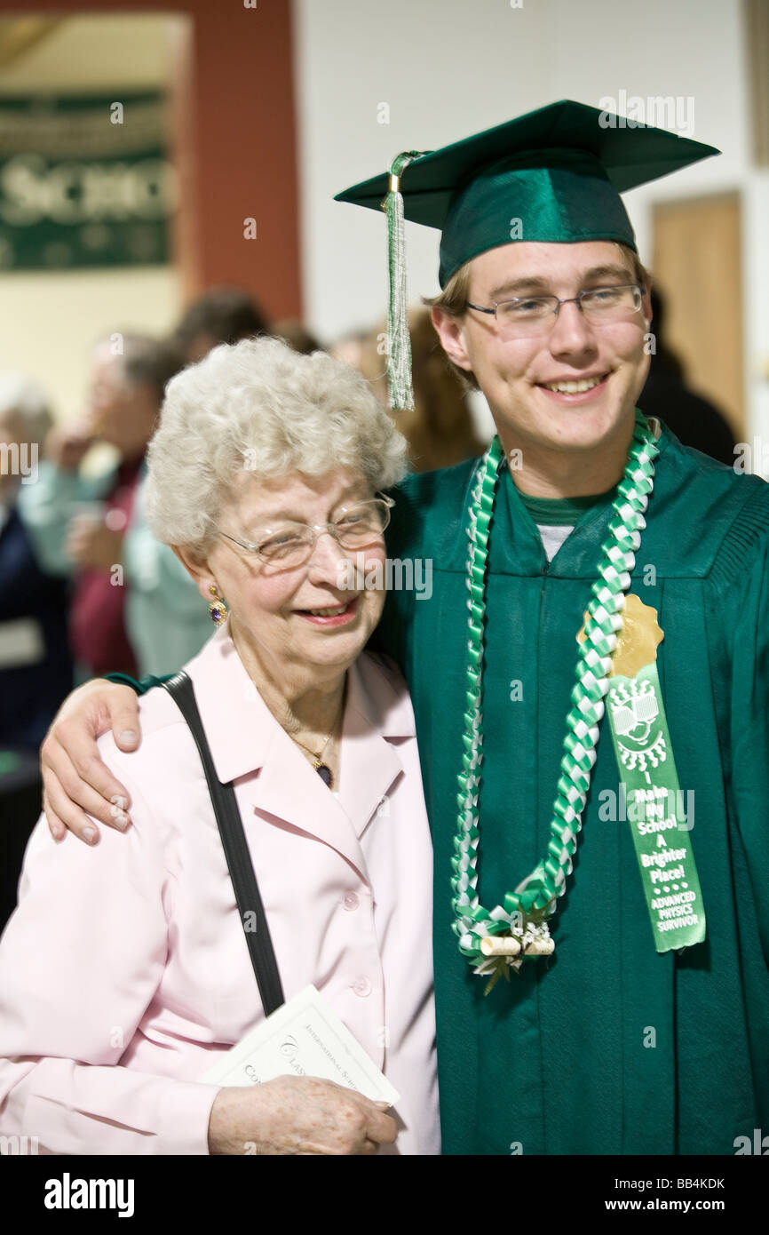 A high school graduate, in cap and gown, stands with his proud grandmother Stock Photo - Alamy
