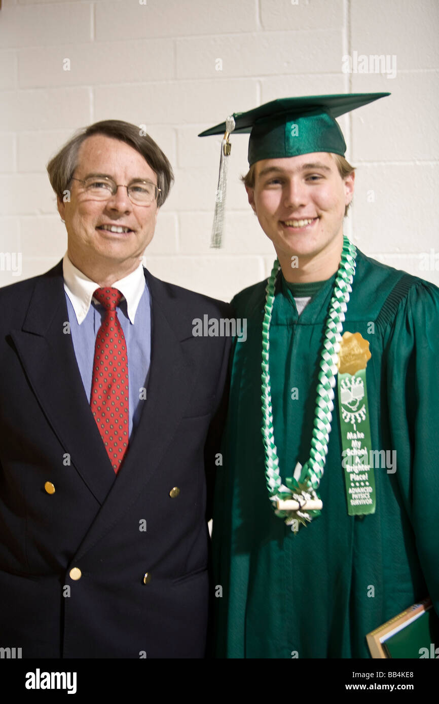 A portrait of a high school graduate, in cap and gown, with his father ...
