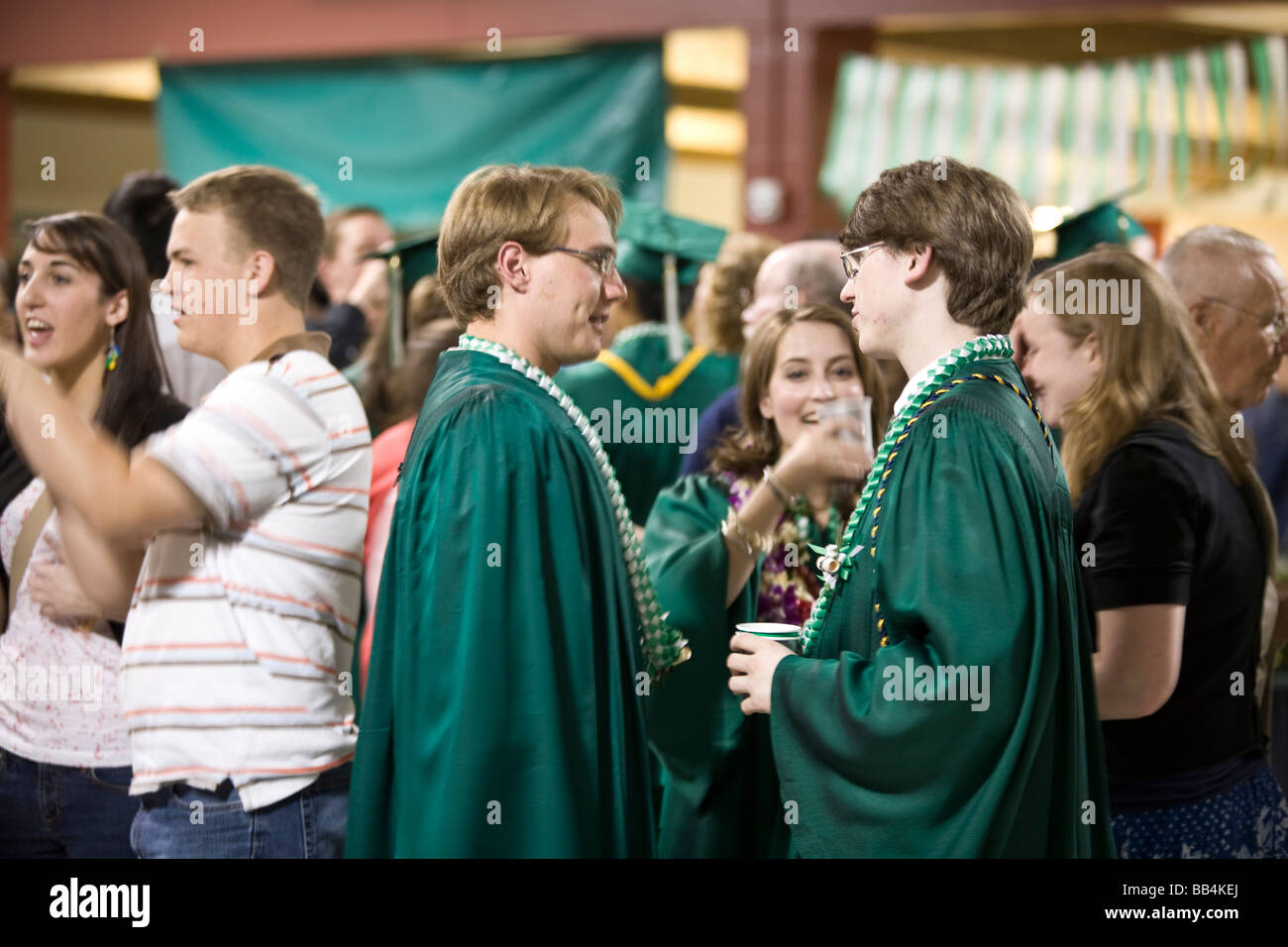 New graduates mingle with parents and friends after their high school ...