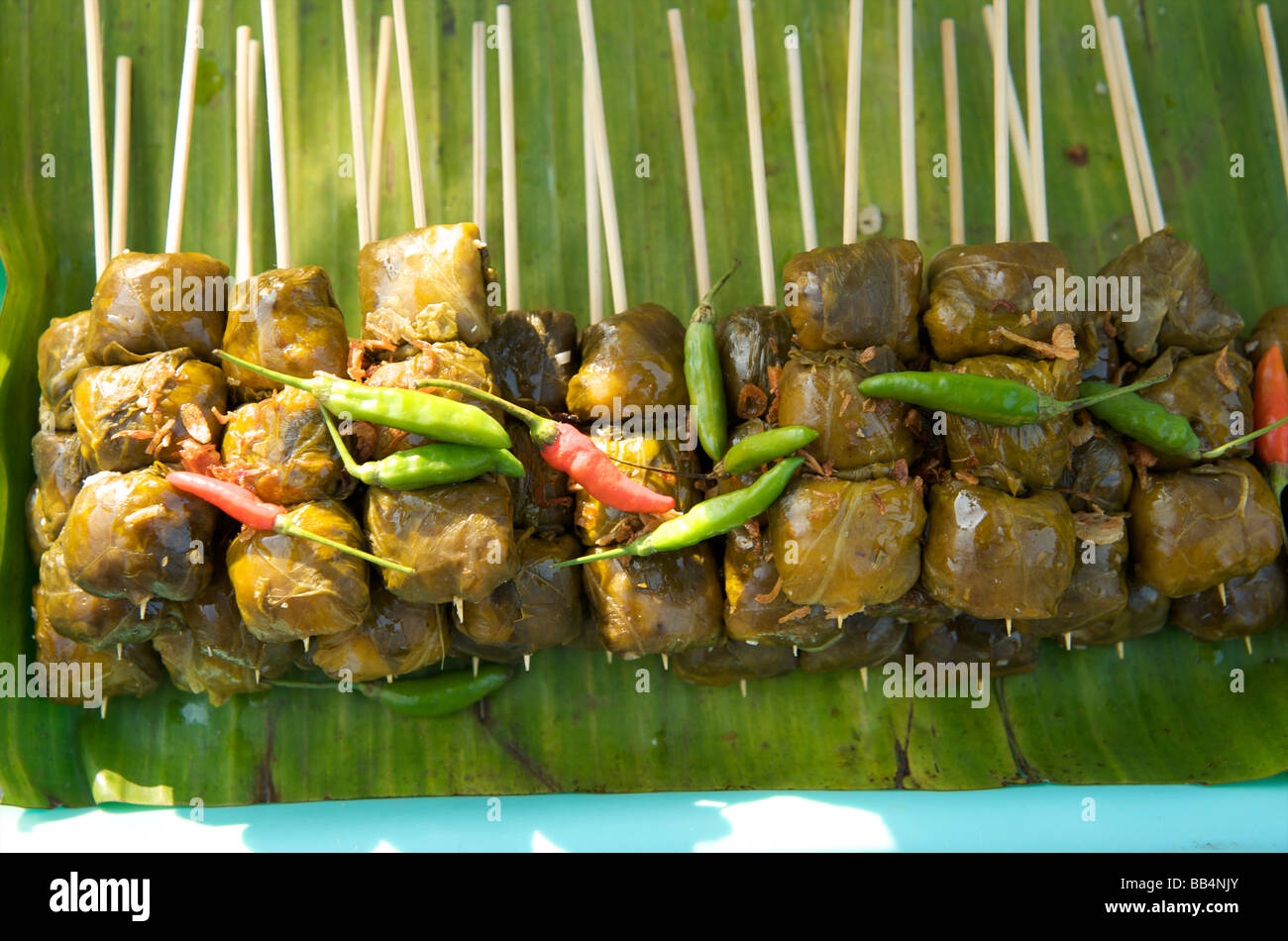 Cooked skewered chilli minced pork leaf parcels ready for eating on a ...