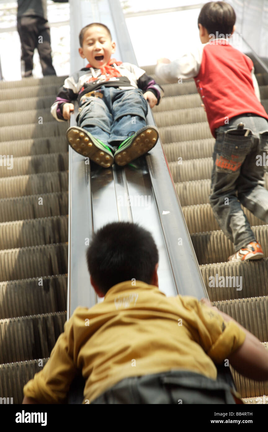 Kids playing on escalator in China Stock Photo - Alamy