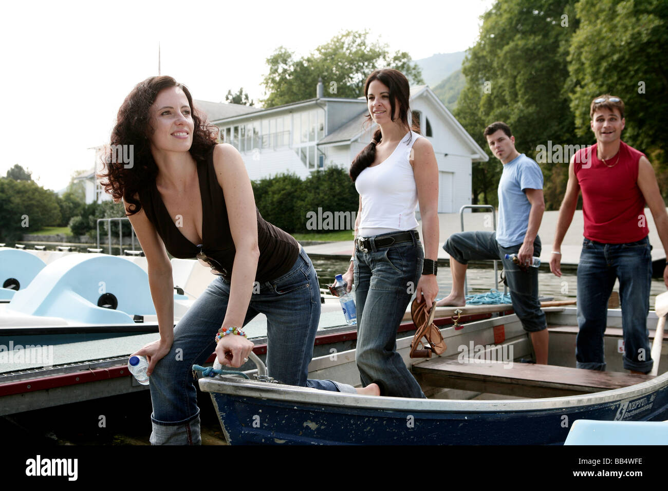 two couples are getting out from a rowboat Stock Photo - Alamy