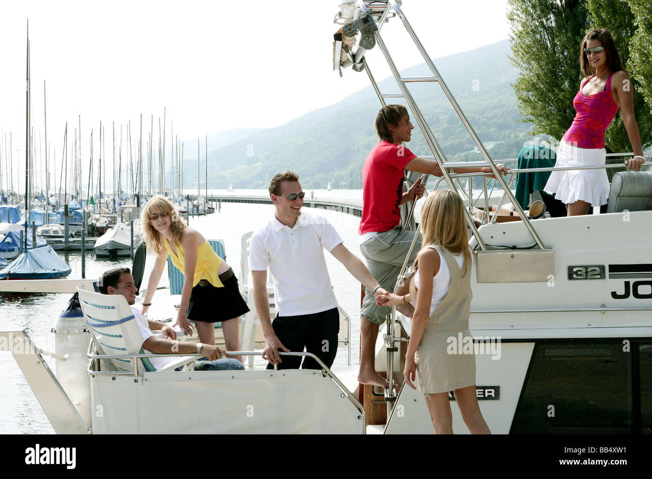young group on a yacht in a port Stock Photo - Alamy