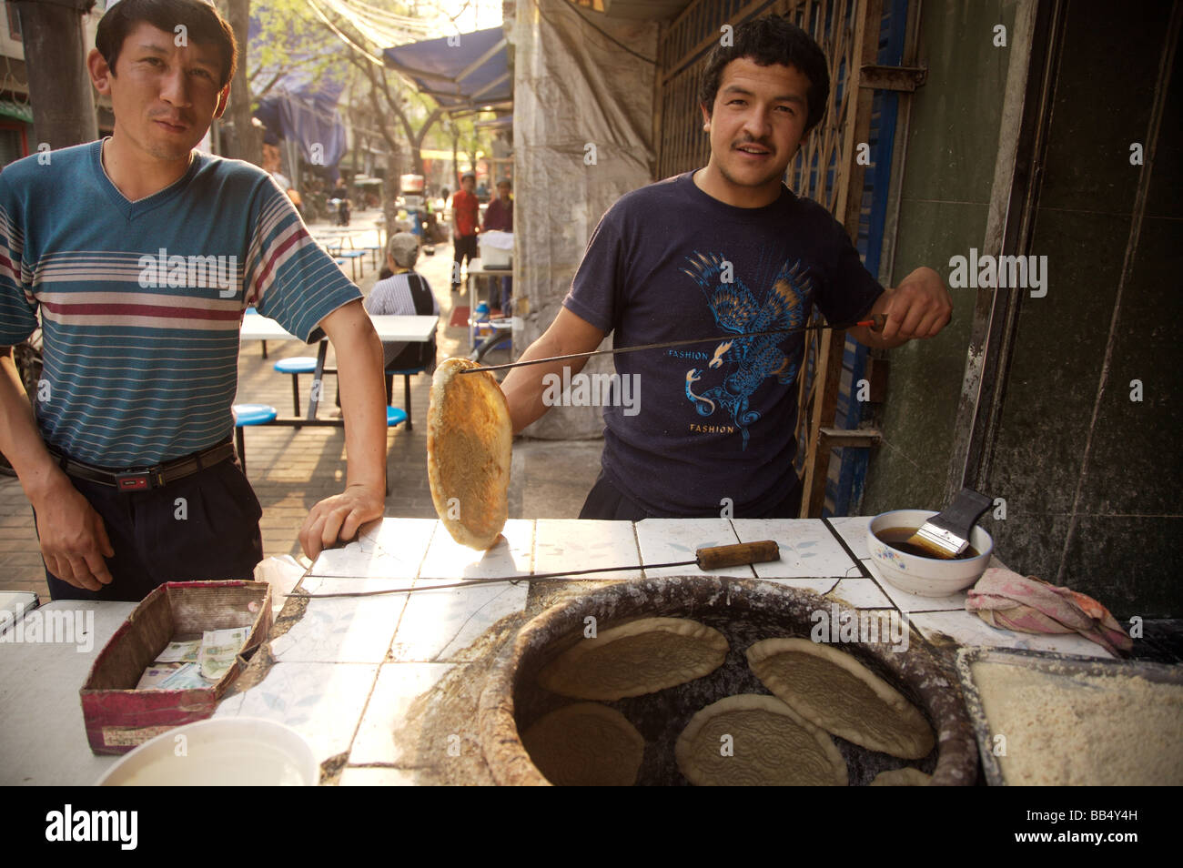 Men in the muslim quarter bake bread in round oven Stock Photo - Alamy