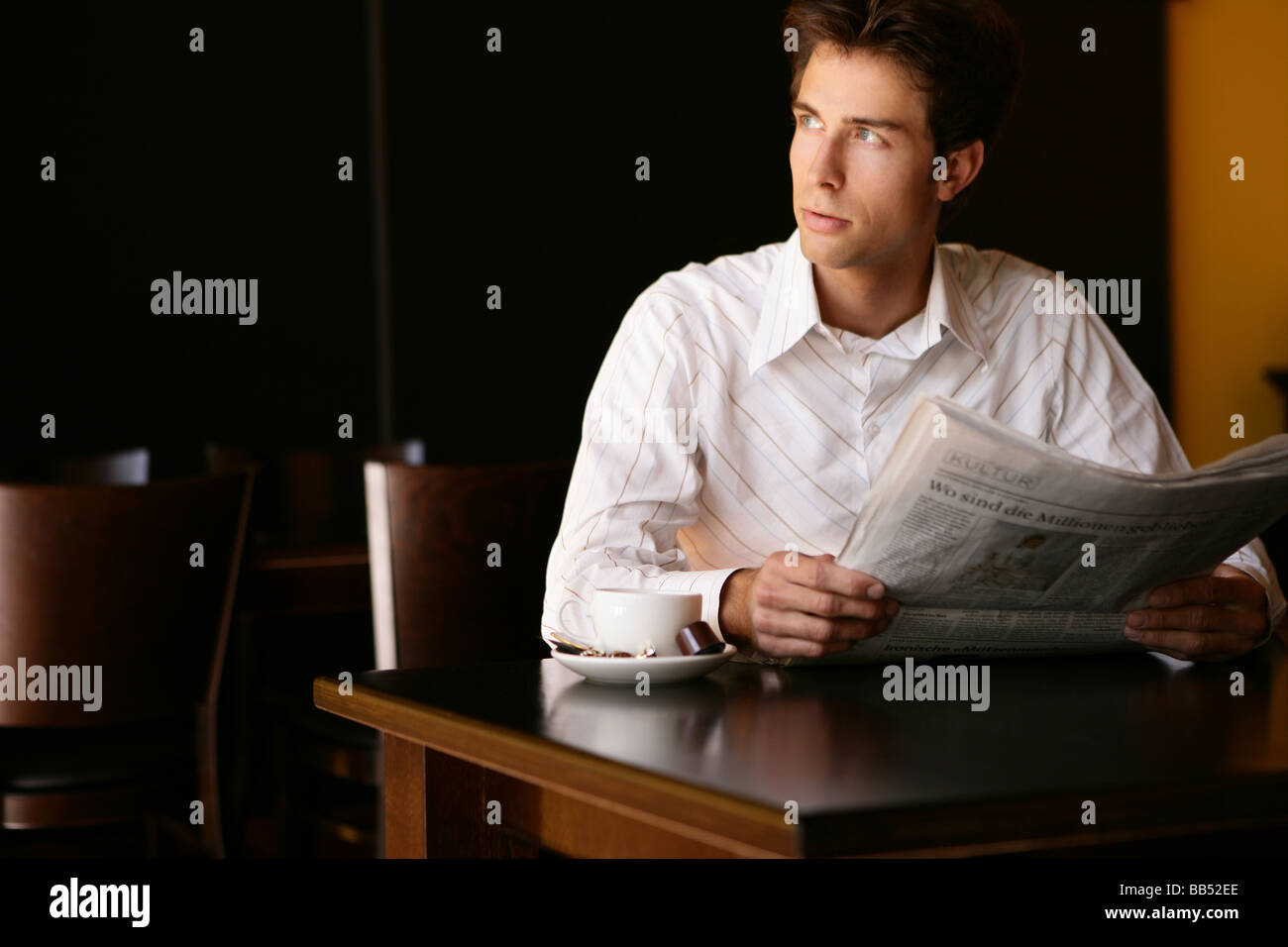 young man with a newspaper in cafe Stock Photo - Alamy