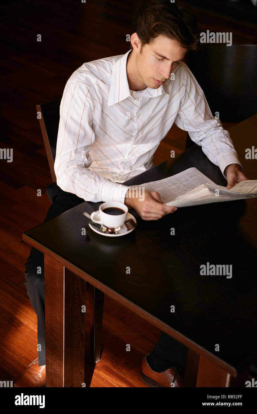 young man with a newspaper in cafe Stock Photo - Alamy