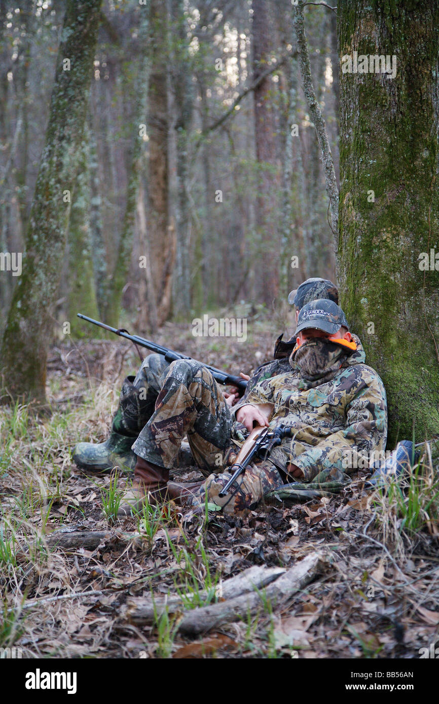 CLOSE UP PORTRAIT HUNTERS RESTING AGAINST A TREE LOOKING LISTENING ...