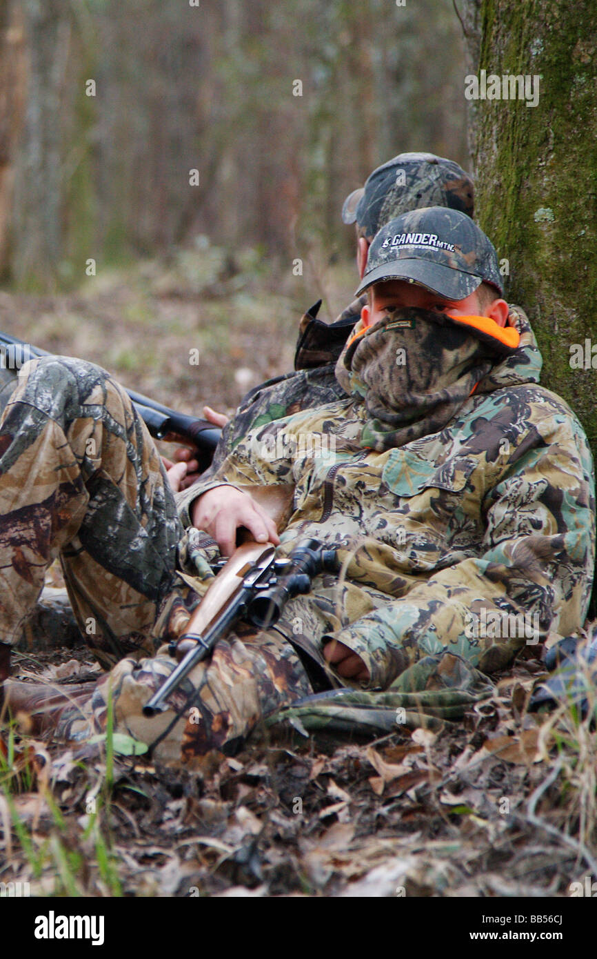 CLOSE UP PORTRAIT HUNTERS RESTING AGAINST A TREE LOOKING LISTENING ...