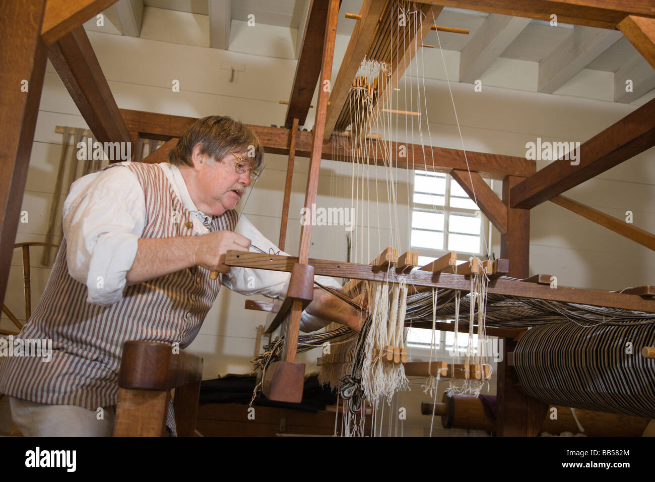 A period actor plays the role of a weaver in Colonial Williamsburg ...