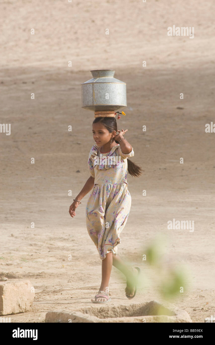 India Rajasthan Masuria young girls carrying water from the well back ...
