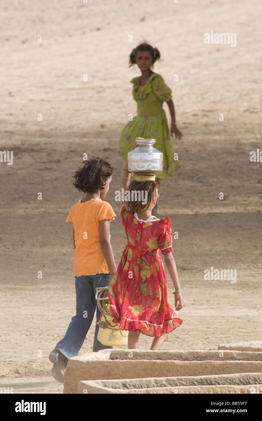India Rajasthan Masuria young girls carrying water from the well back ...