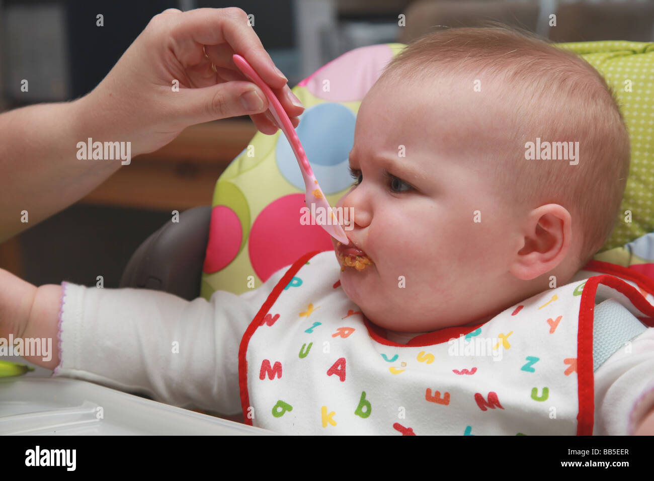 8 month old baby girl being spoon fed Stock Photo - Alamy