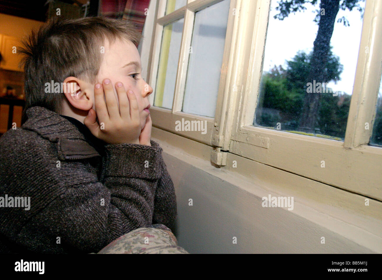 young boy looking out of window Stock Photo - Alamy