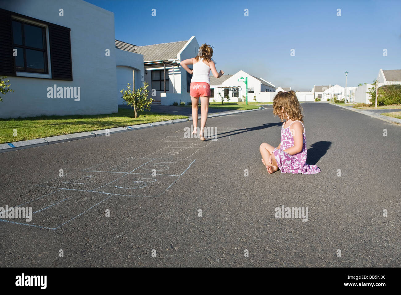 South Africa, Cape Town, two girls playing hopscotch on street Stock ...