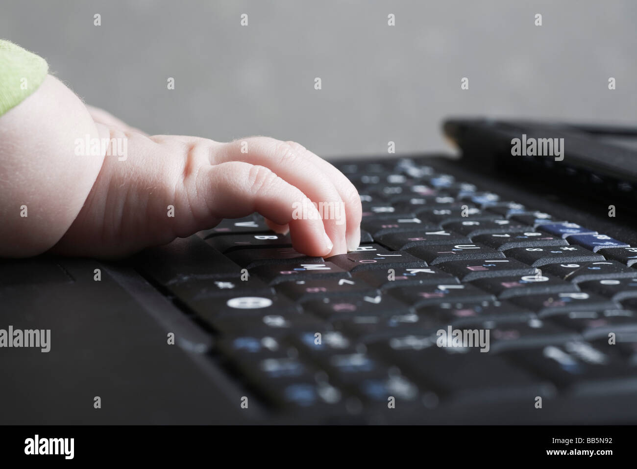 Baby's hand on computer keyboard Stock Photo - Alamy