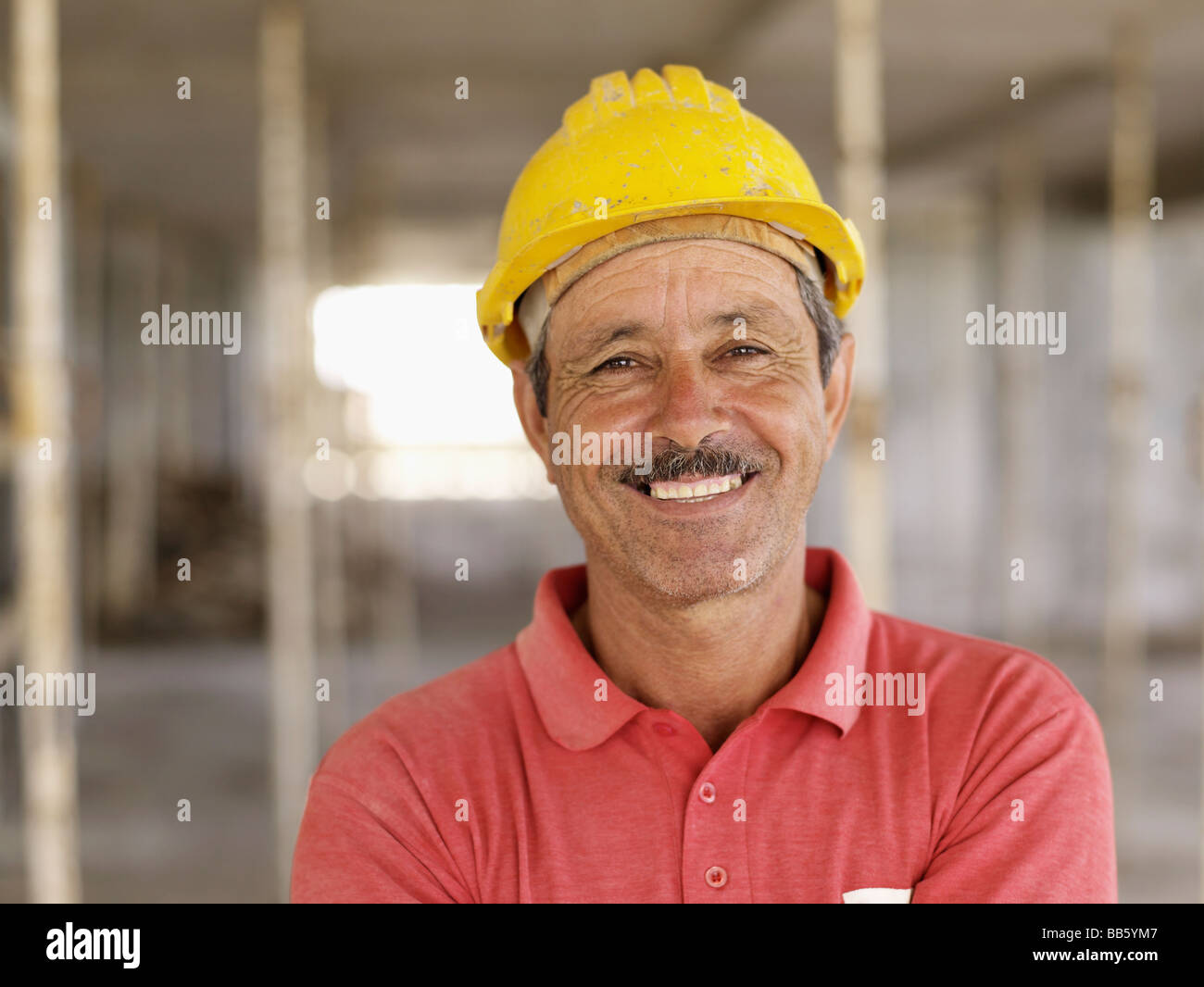 Hispanic worker smiling on construction site Stock Photo - Alamy