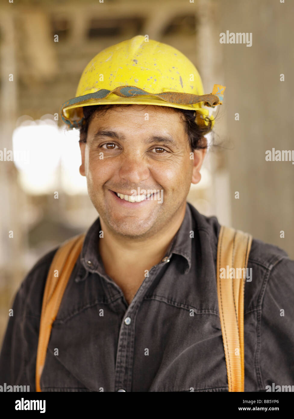 Hispanic worker smiling on construction site Stock Photo - Alamy