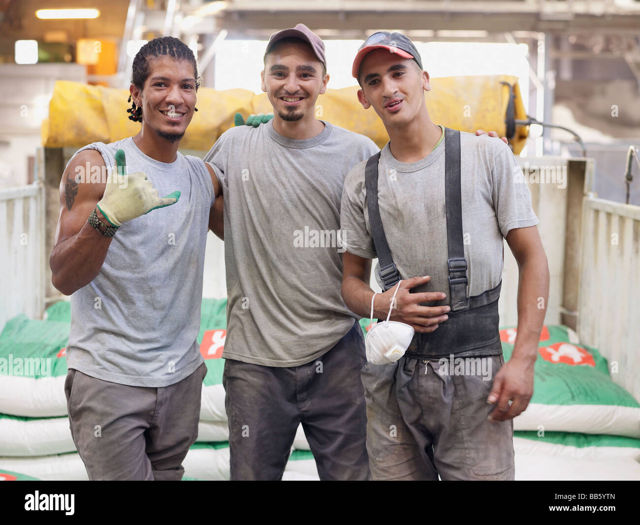 Hispanic workers hugging in factory Stock Photo - Alamy